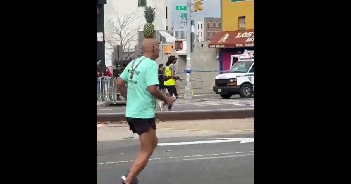 Mann balanciert eine Ananas während er beim Marathon in New York ...